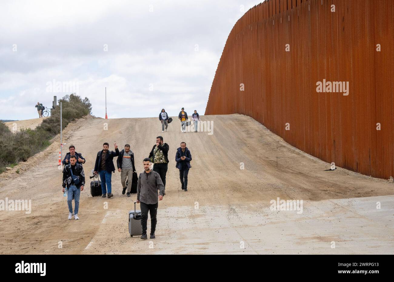 Campo, United States. 13th Mar, 2024. Migrants walk along the United ...