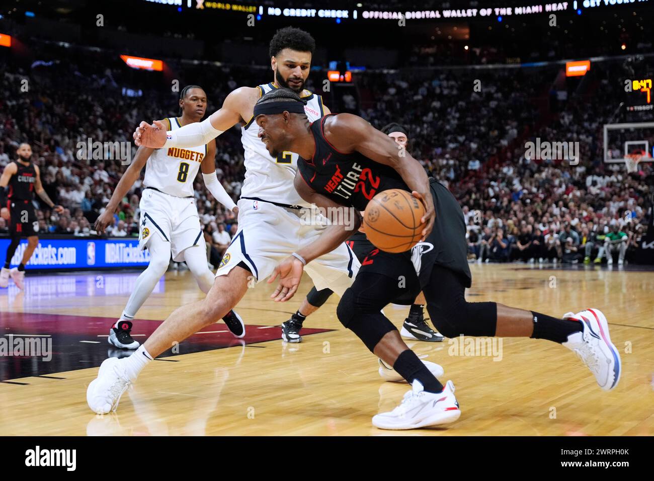 Miami Heat forward Jimmy Butler (22) drives around Denver Nuggets guard ...