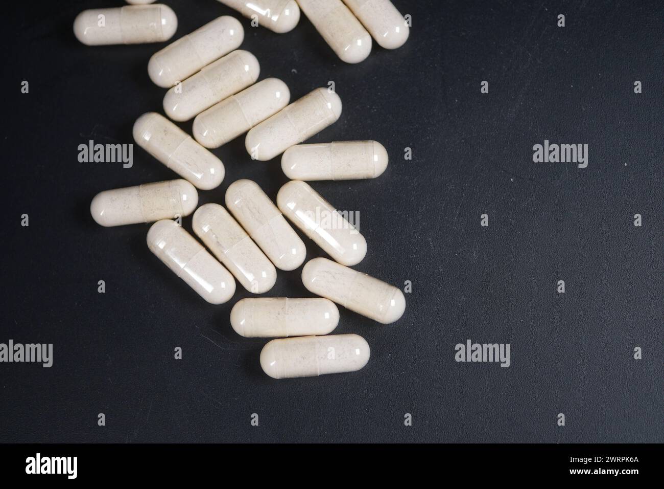 top view of herbal medicine capsule dropping on black background Stock ...