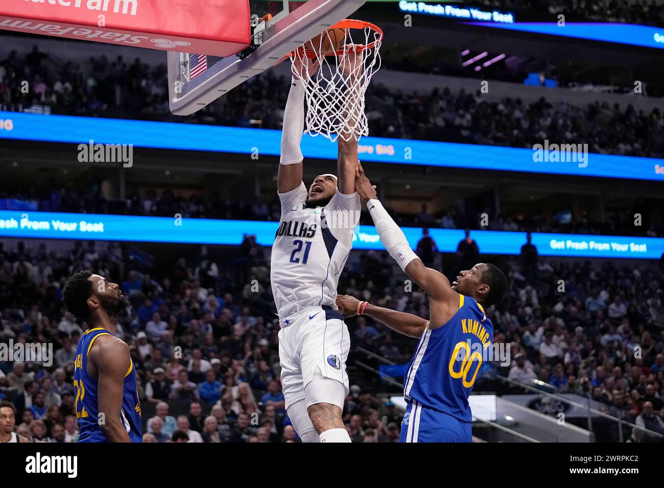 Dallas Mavericks' Daniel Gafford (21) dunks between Golden State Warriors' Andrew Wiggins (22 ...