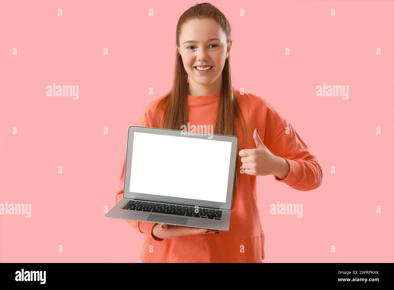 Female programmer with laptop showing thumb-up on pink background Stock ...