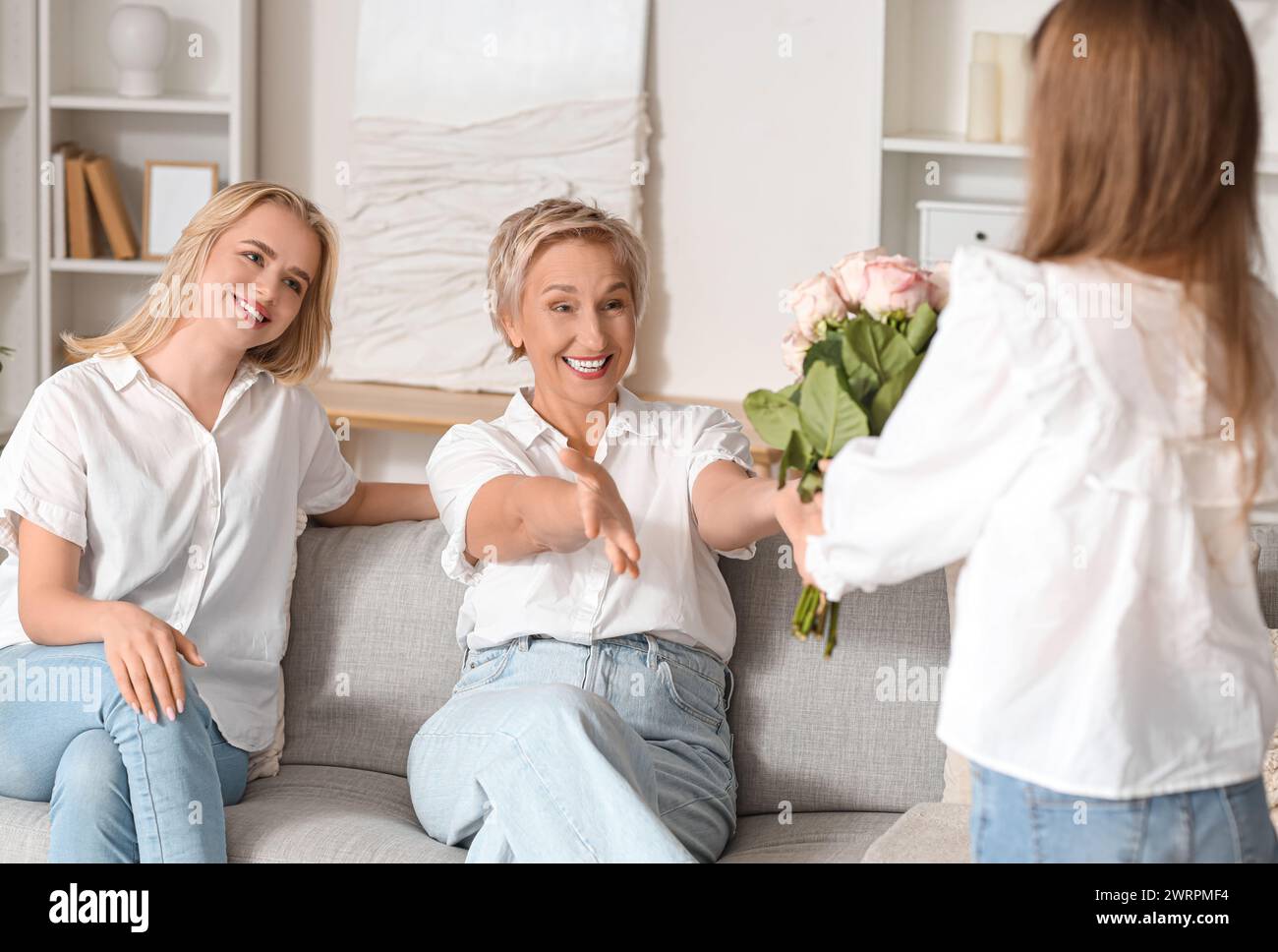 Little girl giving roses to her grandmother and mom at home Stock Photo ...