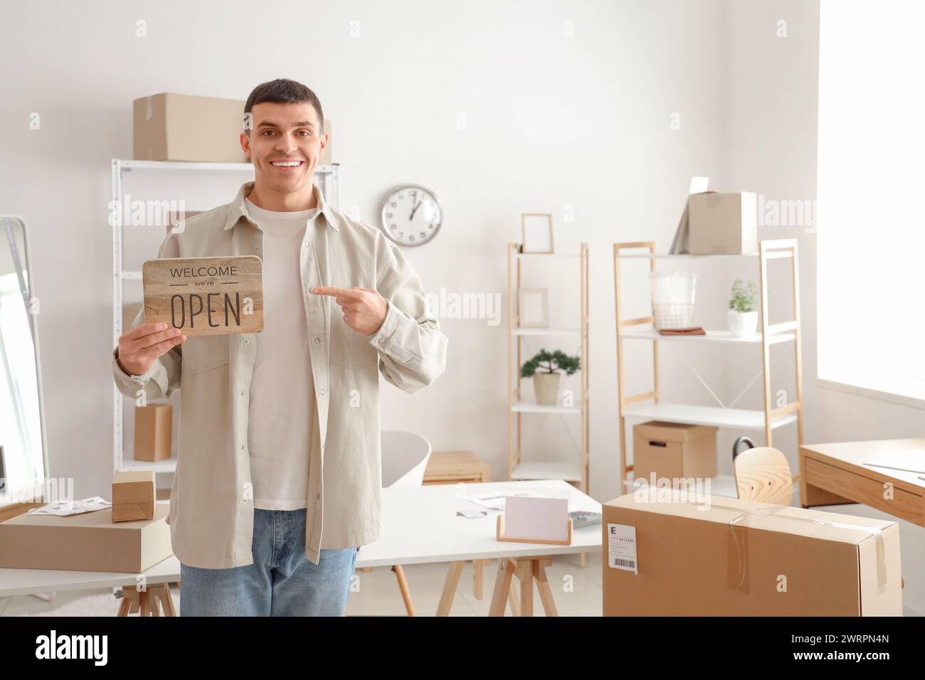 Male online store seller pointing at OPEN sign in warehouse Stock Photo ...