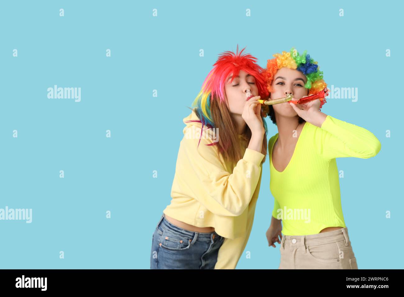 Beautiful young women in funny clown disguise with party whistles on ...