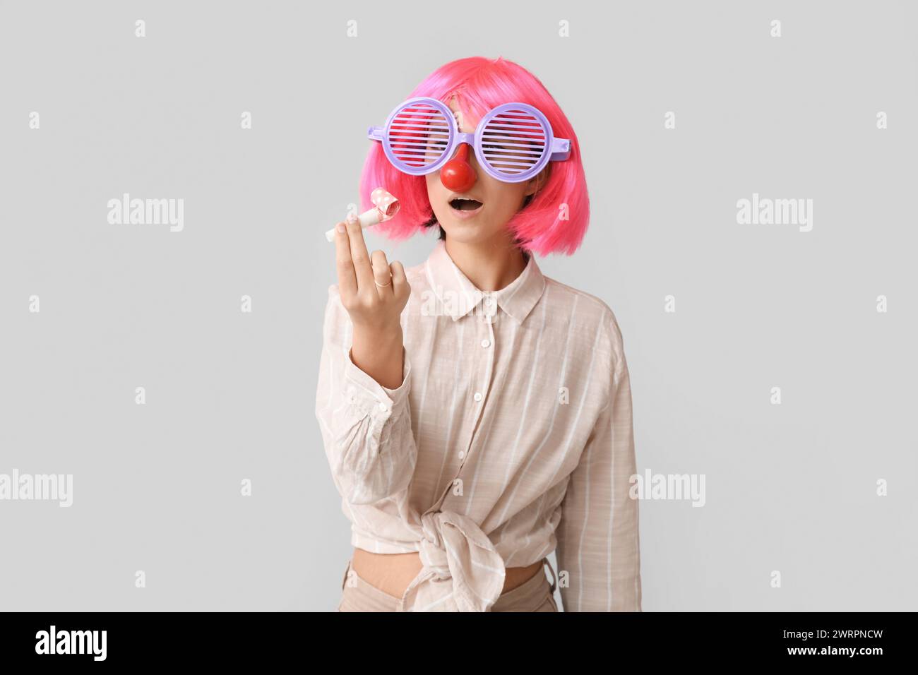 Beautiful young shocked woman in funny disguise with party whistle on ...