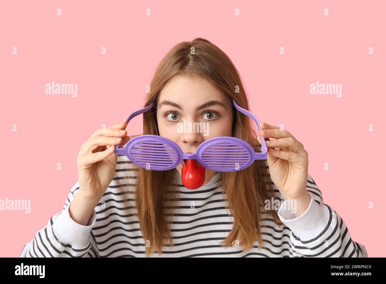 Beautiful young shocked woman in funny disguise on pink background ...