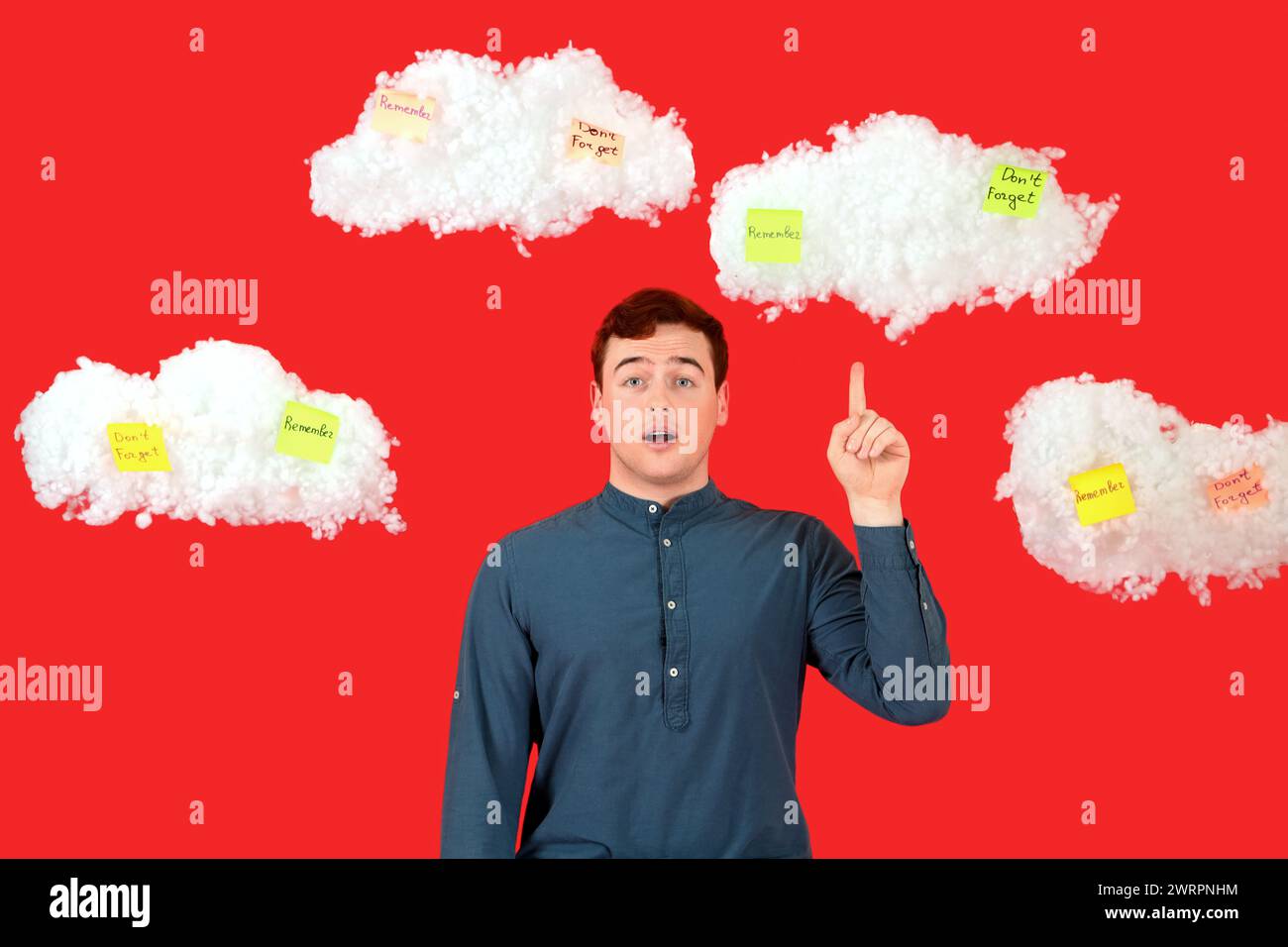 Young man pointing at clouds with reminders on red background Stock ...