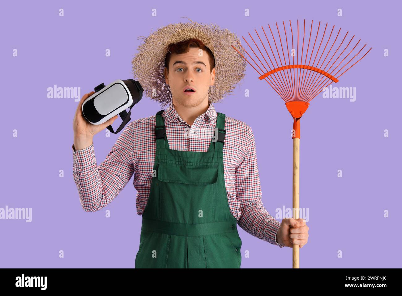 Shocked male farmer with rake and VR glasses on lilac background Stock ...