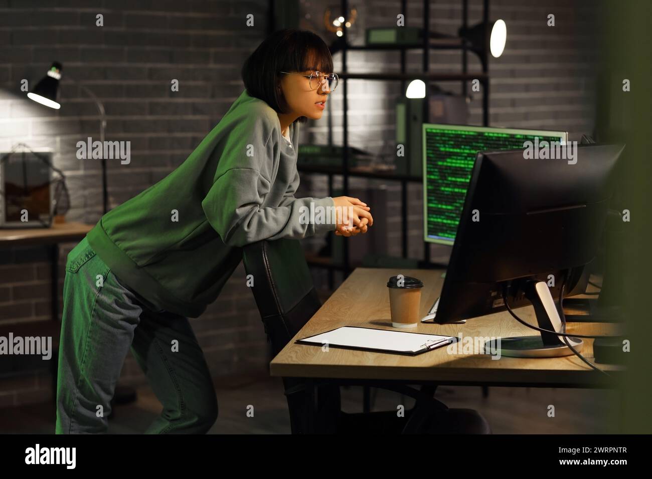 Female programmer working near table in office at night Stock Photo - Alamy