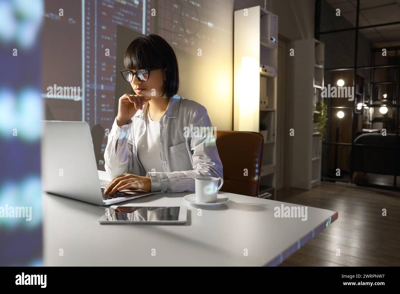 Young female programmer working with laptop in office at night Stock Photo - Alamy