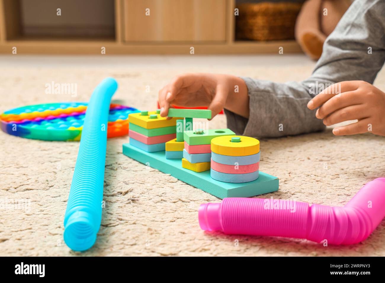 Little girl playing with toys at home, closeup. Autistic disorder ...