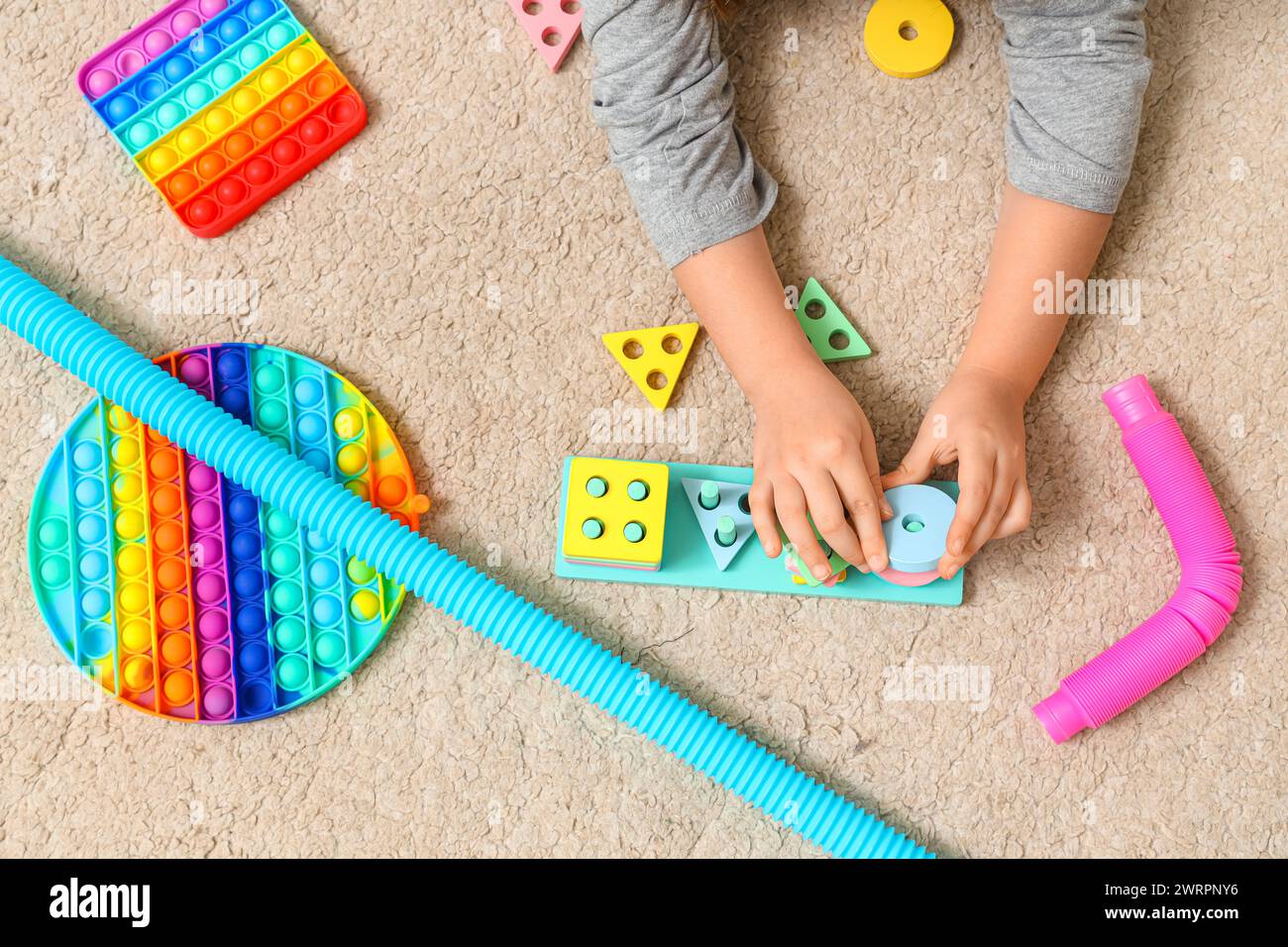 Little girl playing with toys at home, top view. Autistic disorder ...