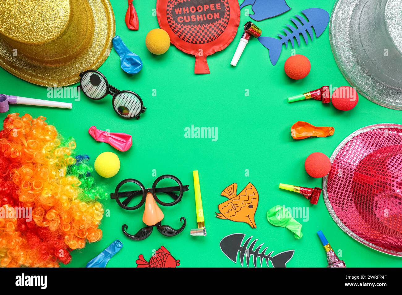 Frame made of hats, funny glasses and party decor on green background ...