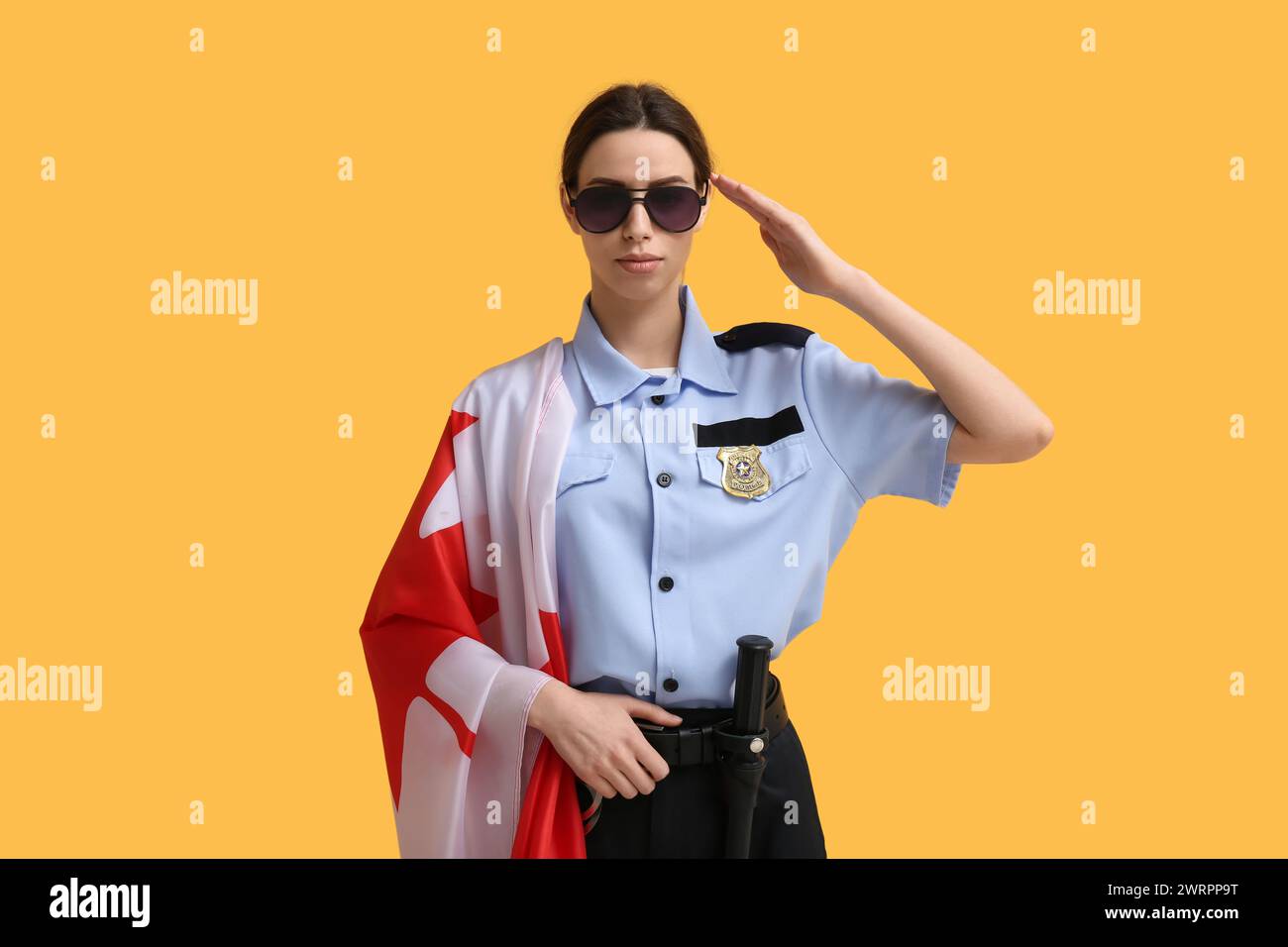 Saluting female police officer with flag of Canada on yellow background ...
