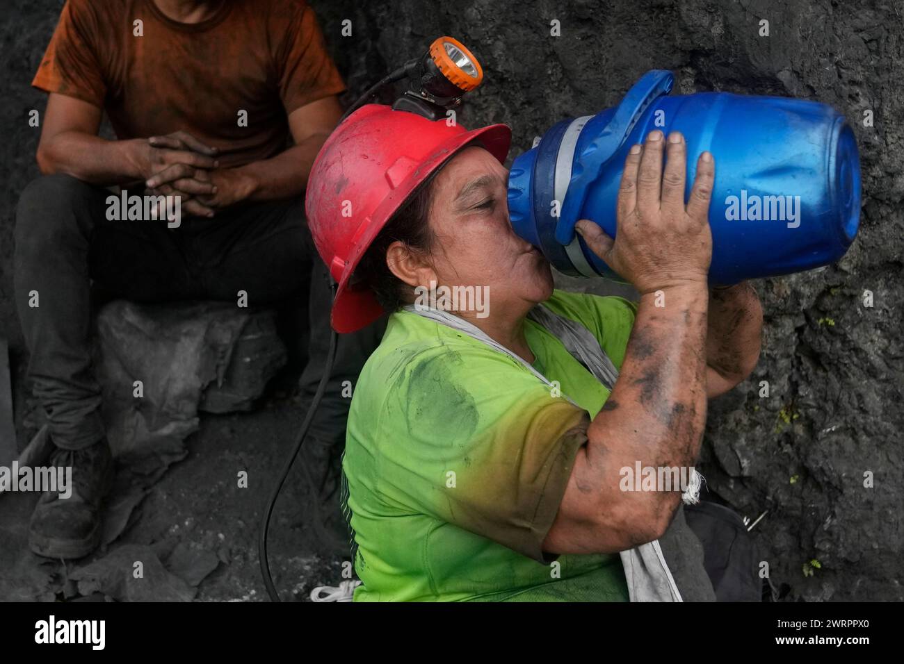 Emerald miner Yaneth Forero, 52, hydrates during a break outside an ...
