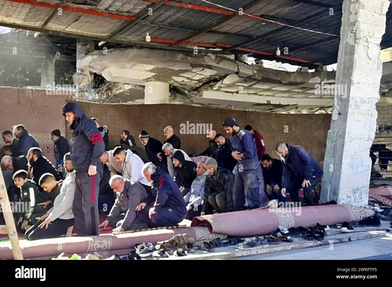 People pray at a damaged mosque in Rafah, Gaza on March 11, 2024, amid ...