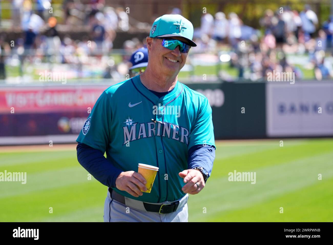 Seattle Mariners manager Scott Servais smiles as he walks to the dugout ...