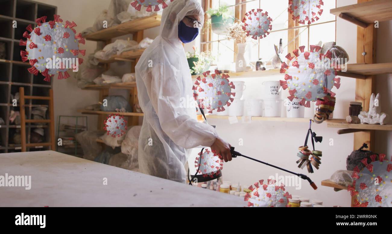 Image of virus cells over caucasian man with face mask and safety suit ...