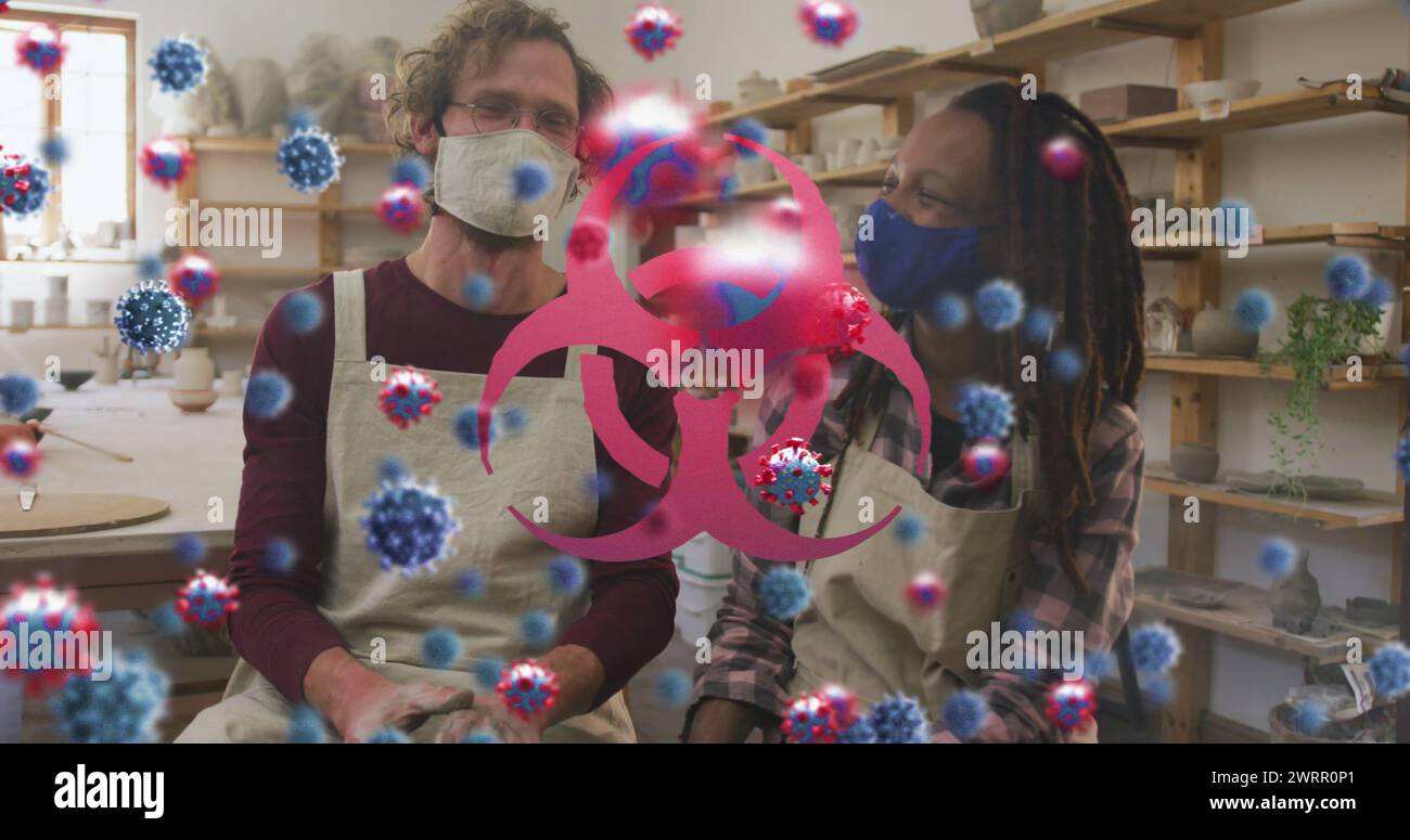 Image of virus cells and biohazard symbol over diverse workers with ...