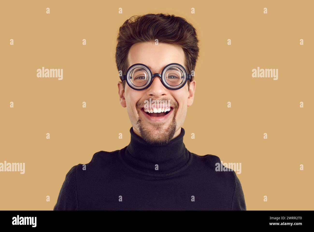 Funny young man in glasses with magnified lenses laughs isolated on ...