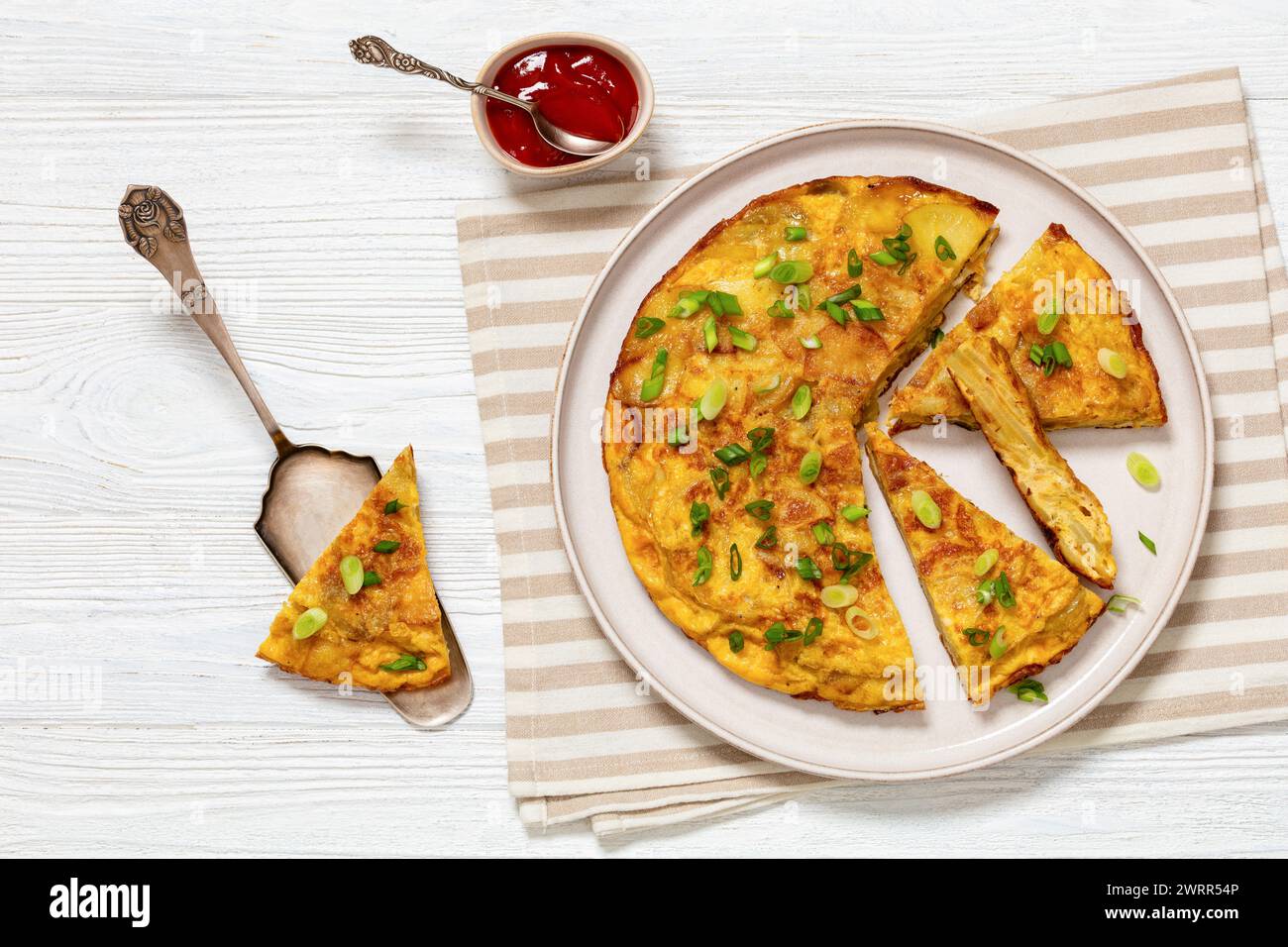 traditional spanish potato omelette, tortilla espanola sliced on plate ...