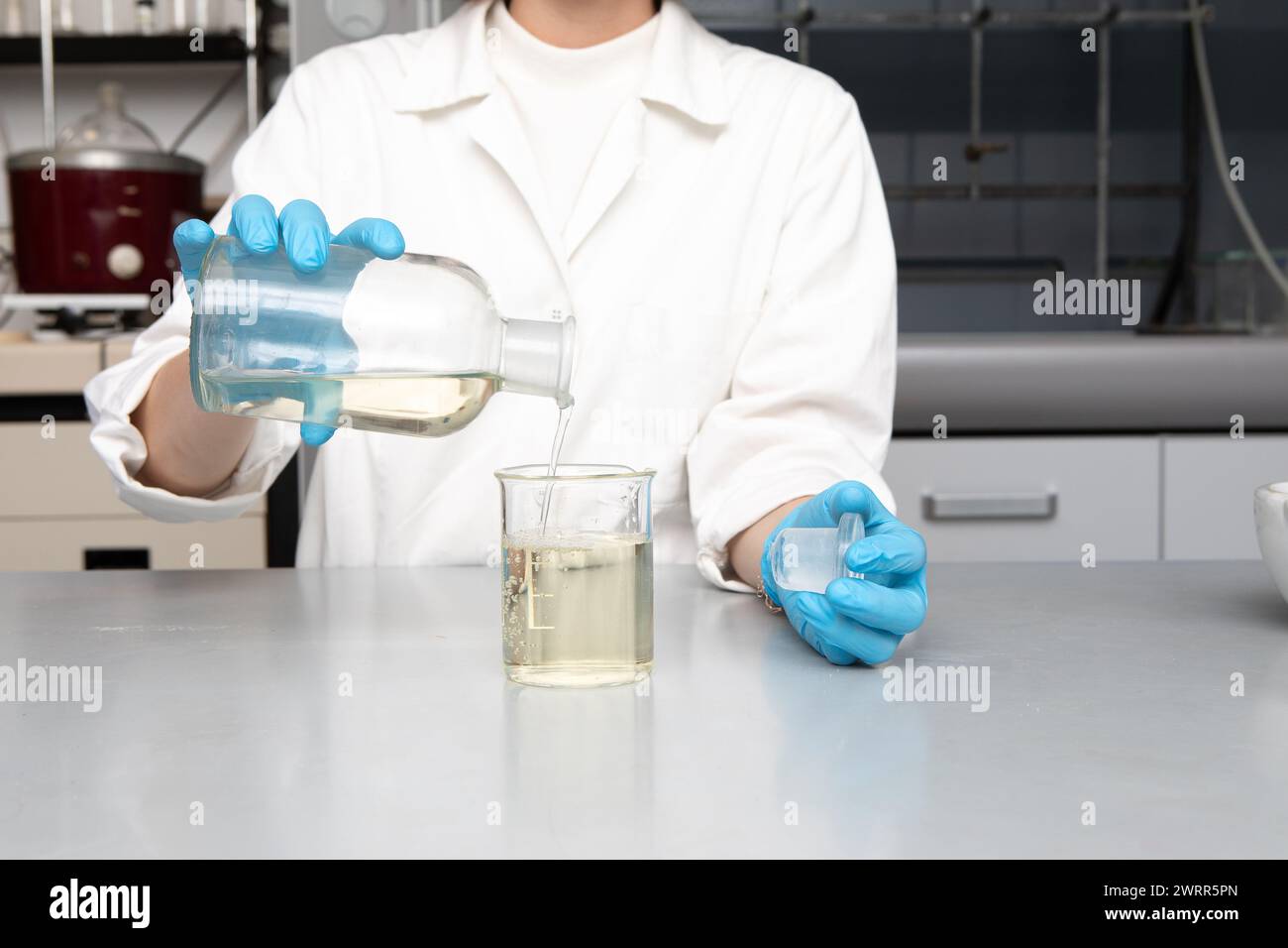 Pouring chemicals for an analysis in a beaker, showcasing a typical ...