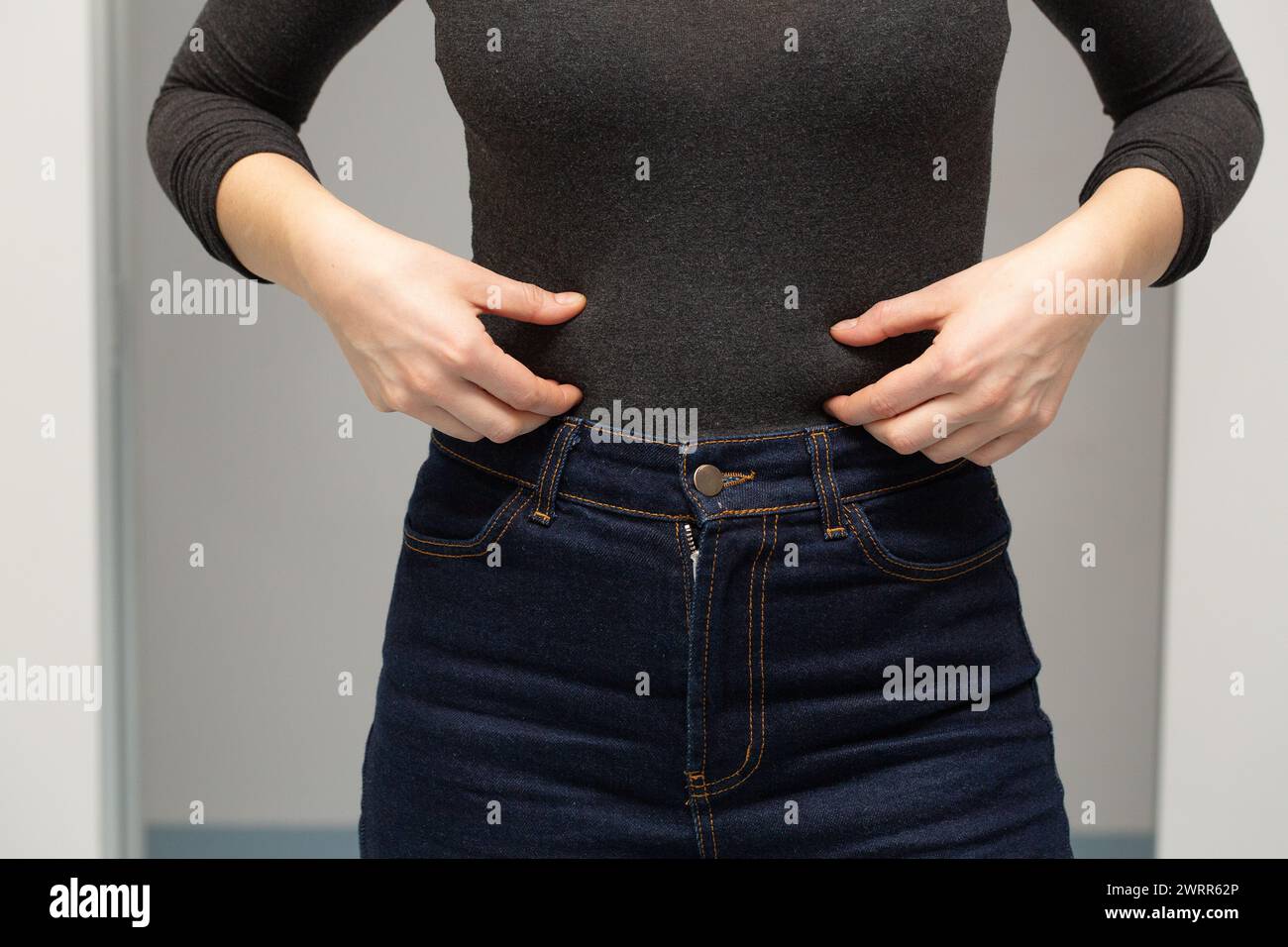 Midsection of a fit woman with hands on hips, showcasing a slim ...