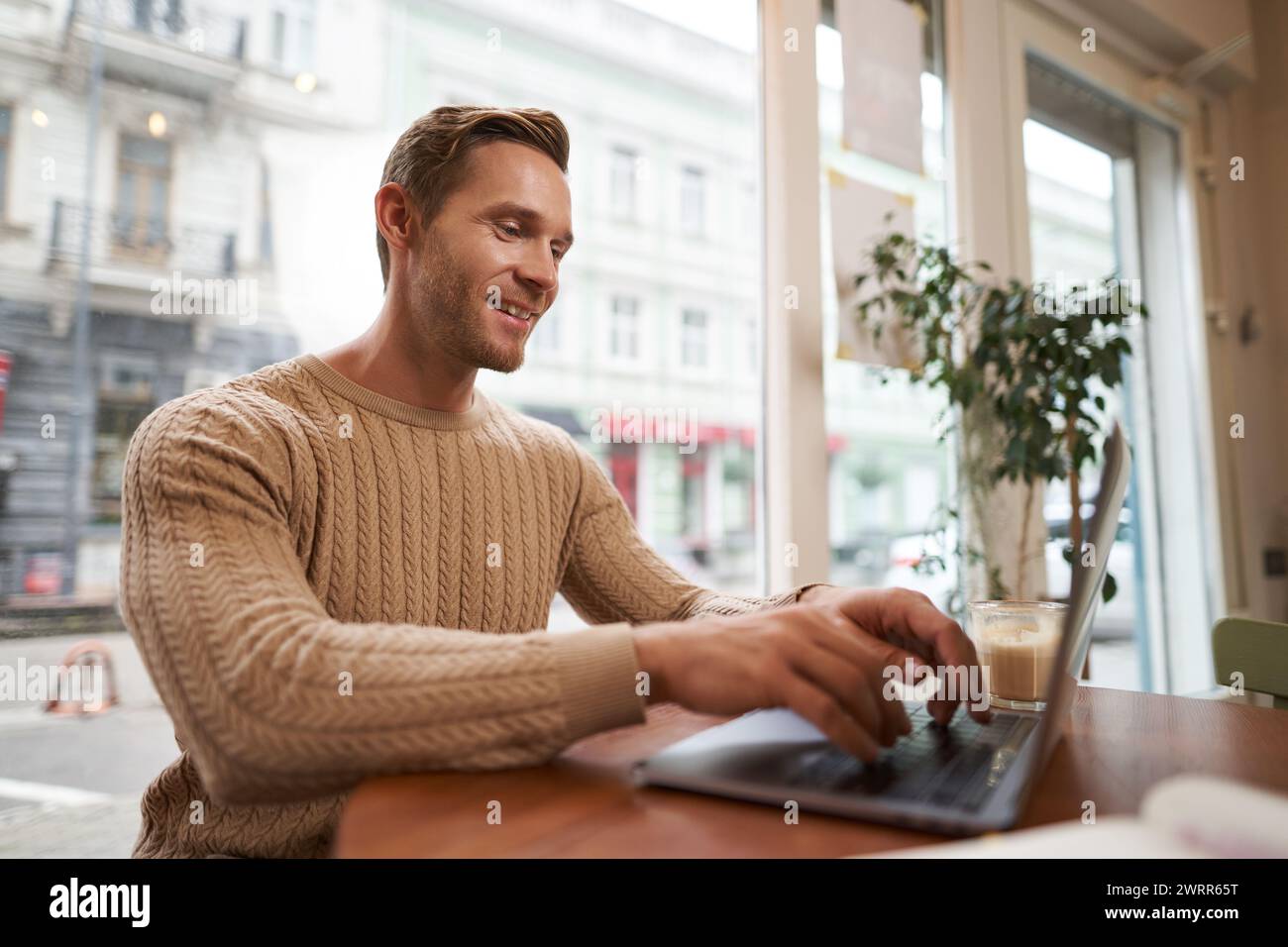 Laughing handsome man typing something hi-res stock photography and ...