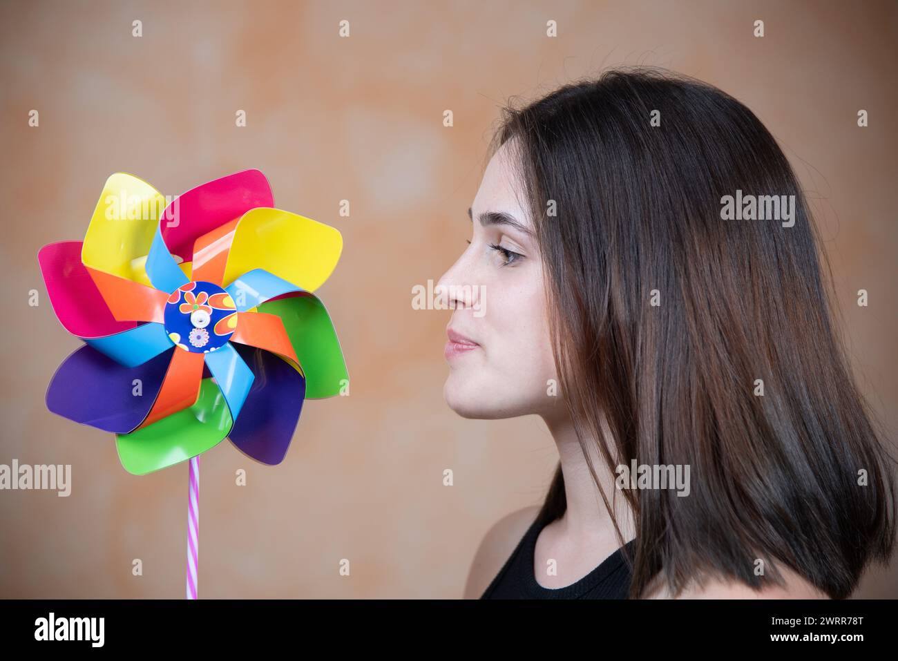 Side profile of a young woman looking at a vibrant pinwheel Stock Photo ...