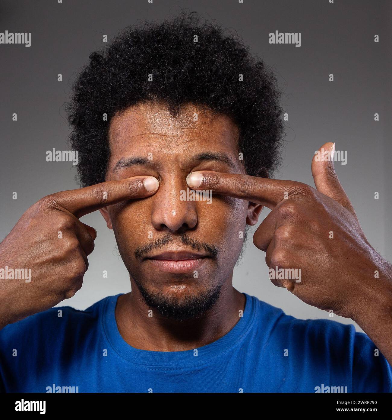 A close-up image of an individual with their fingers pressed against ...