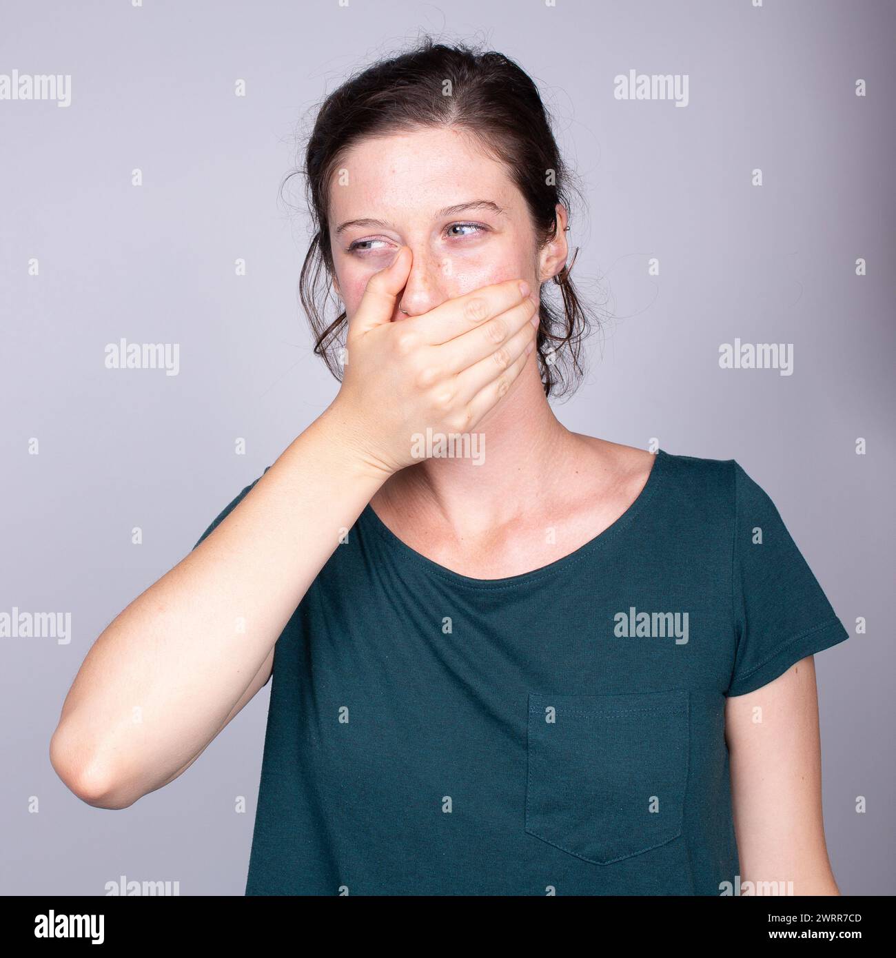 A portrait of an individual with their hand on their cheek, visibly in ...