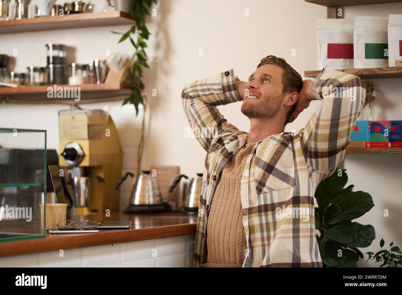 Portrait of man with pleased face, stretching after finishing work or ...