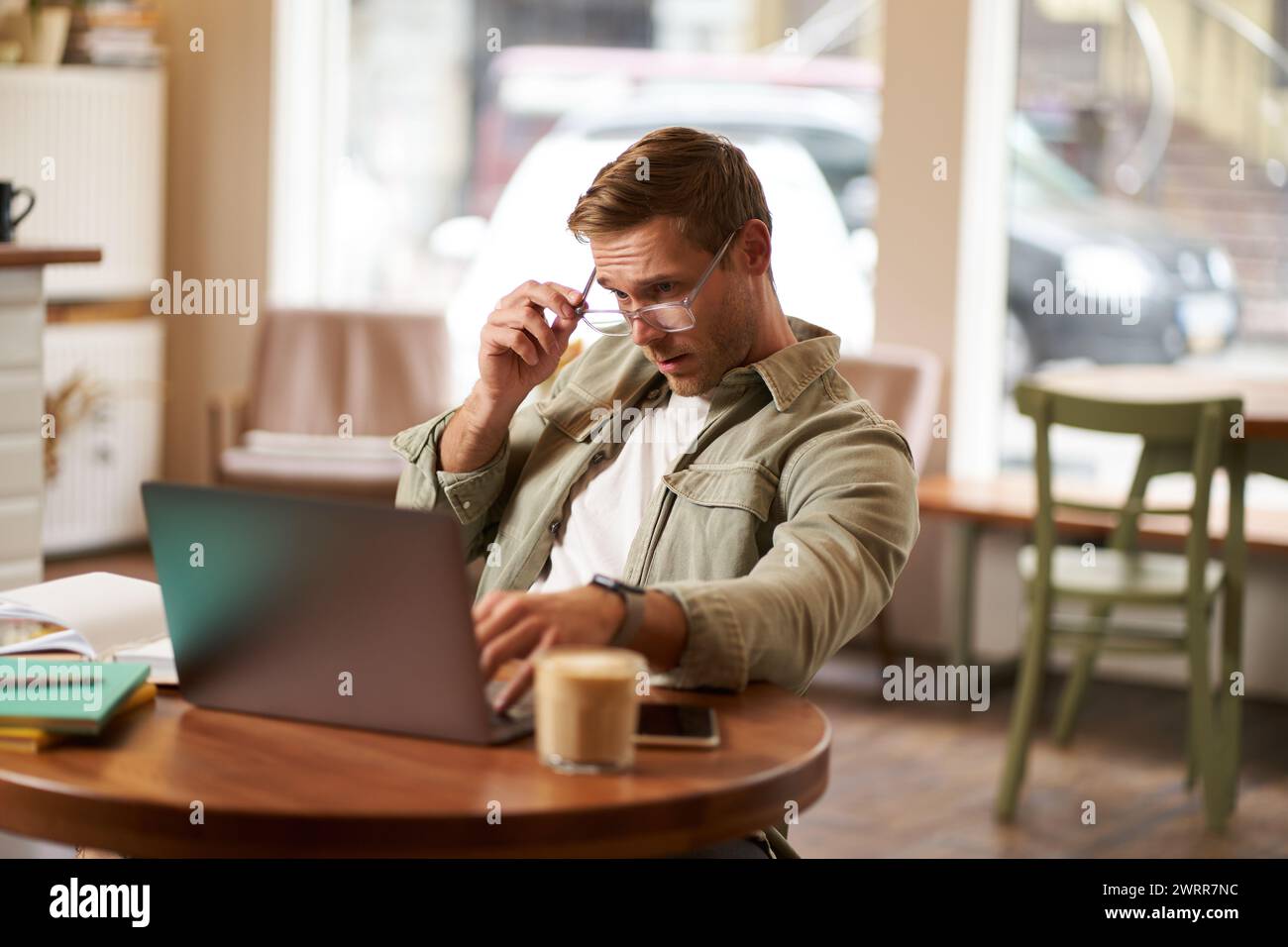 Portrait Of A Man Working In Cafe Looking Surprised At Camera Taking