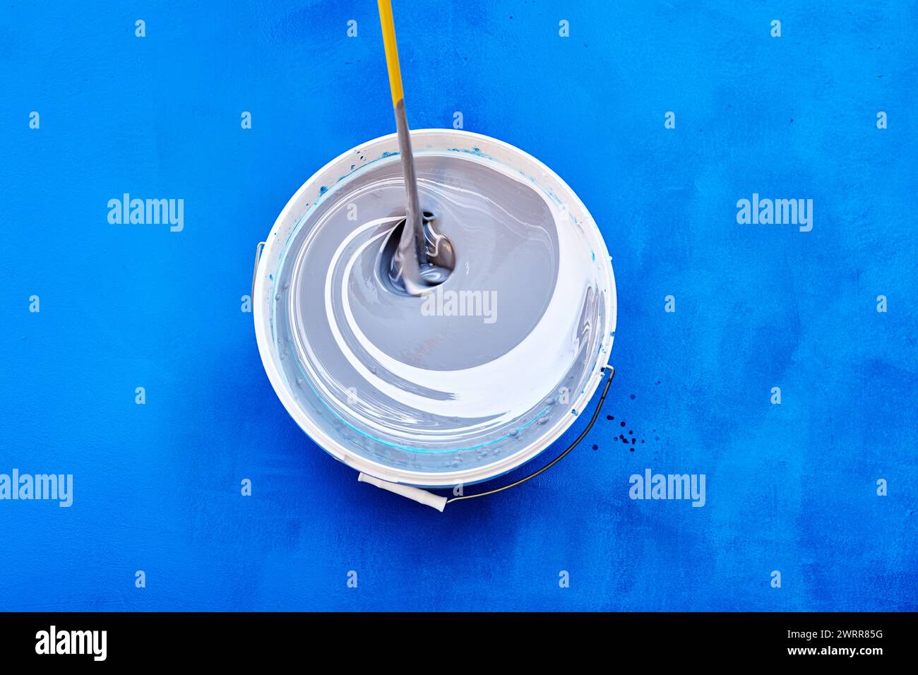 Tinting and mixing paint with stirring rod or mixer for paints, house ...