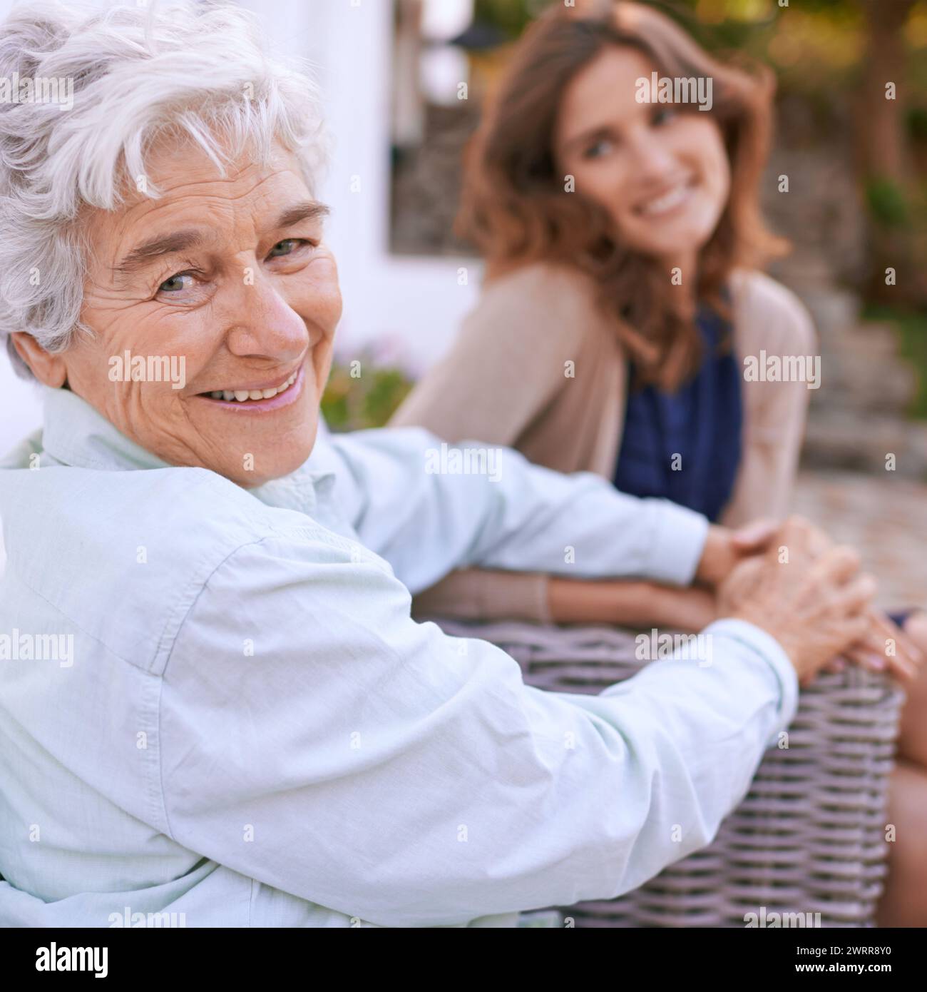 Portrait, elderly and mother together with daughter in nursing home, outdoor and woman to visit ...