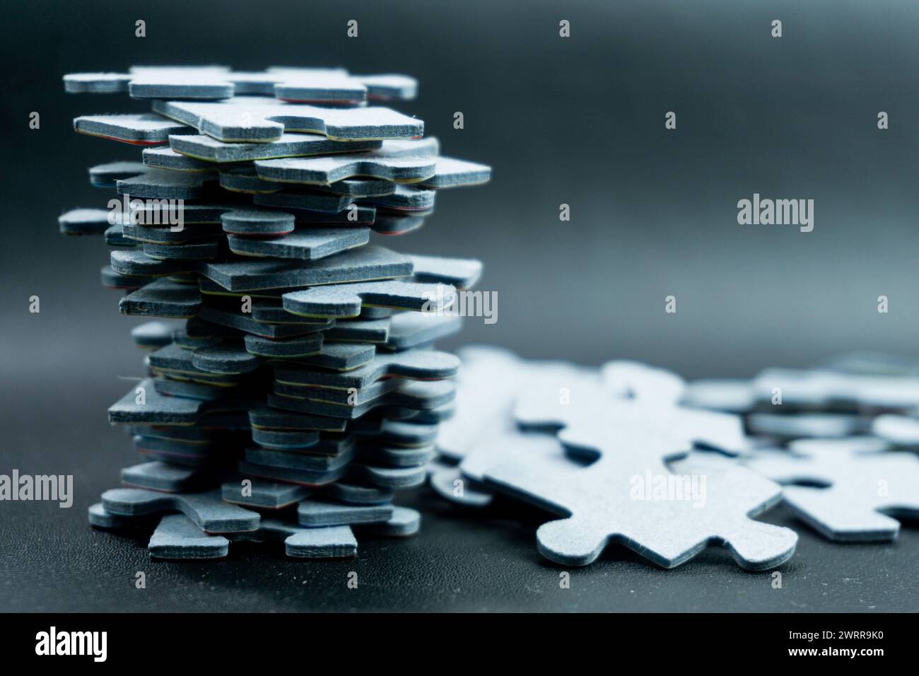 Stacked unfinished puzzle pieces on black background. Vertical stack ...