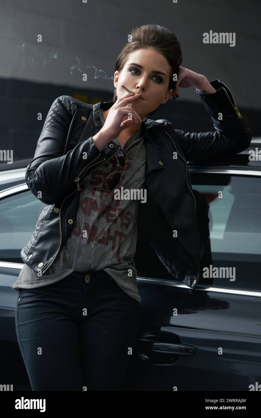 Woman, waiting and smoking cigarette on car in parking lot for pick up ...