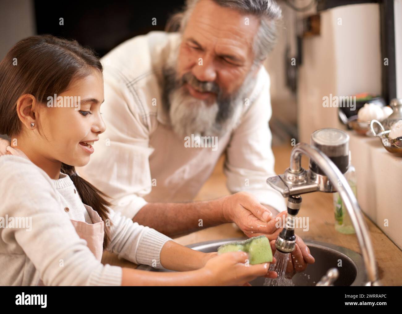 Grandfather, child and washing hands with water to clean in kitchen ...