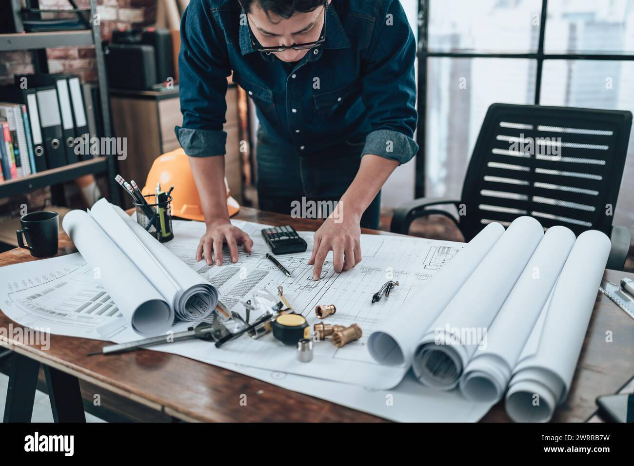 Engineering working with drawings inspection on the office desk and ...
