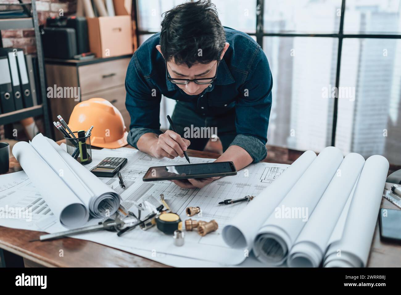 Engineering working with drawings inspection on tablet in the office ...