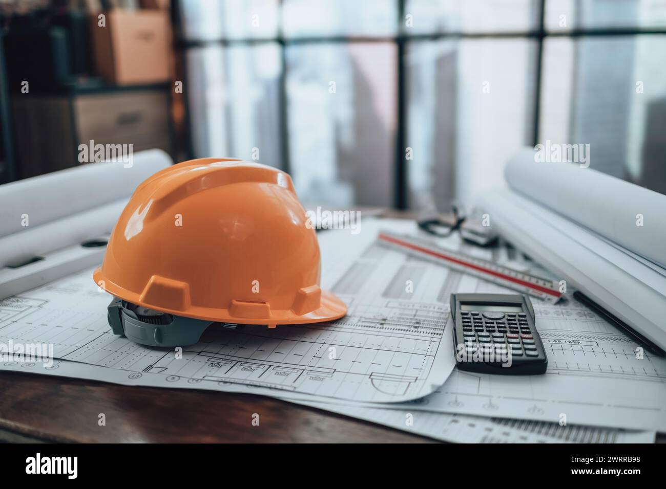 Engineer safety helmet with drawings inspection on the office desk and ...
