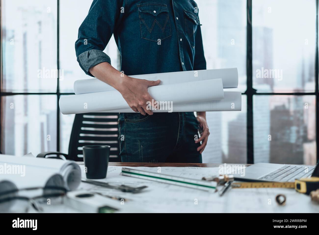 Engineering holding paper roll drawings in the office and Calculator ...