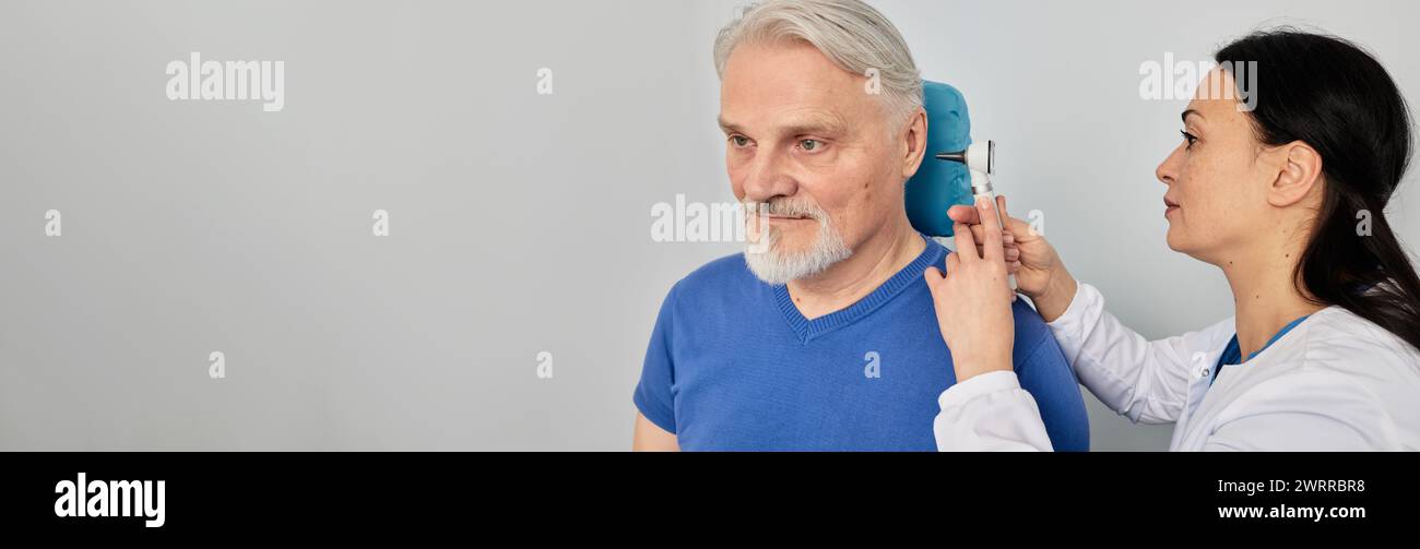 Senior man during ear test with audiologist at hearing clinic ...