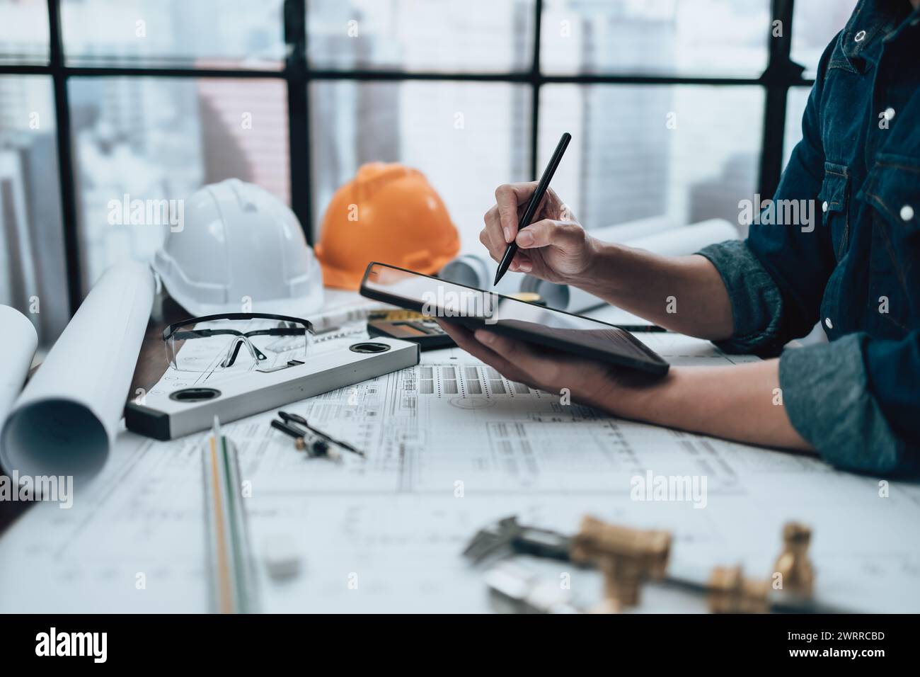 Engineering working with drawings inspection on tablet in the office ...