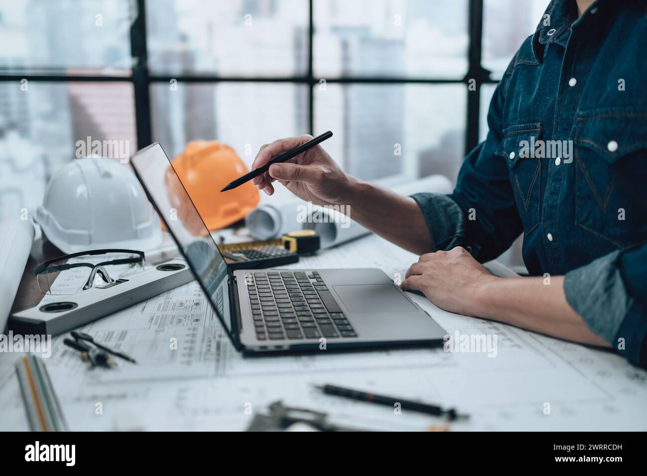 Engineering working with drawings inspection on laptop in the office ...