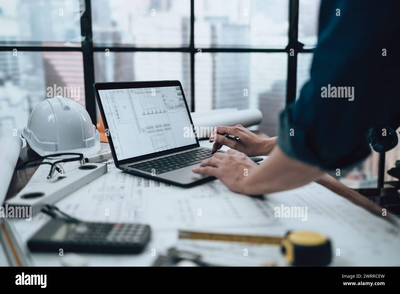 Engineering working with drawings inspection on laptop in the office ...