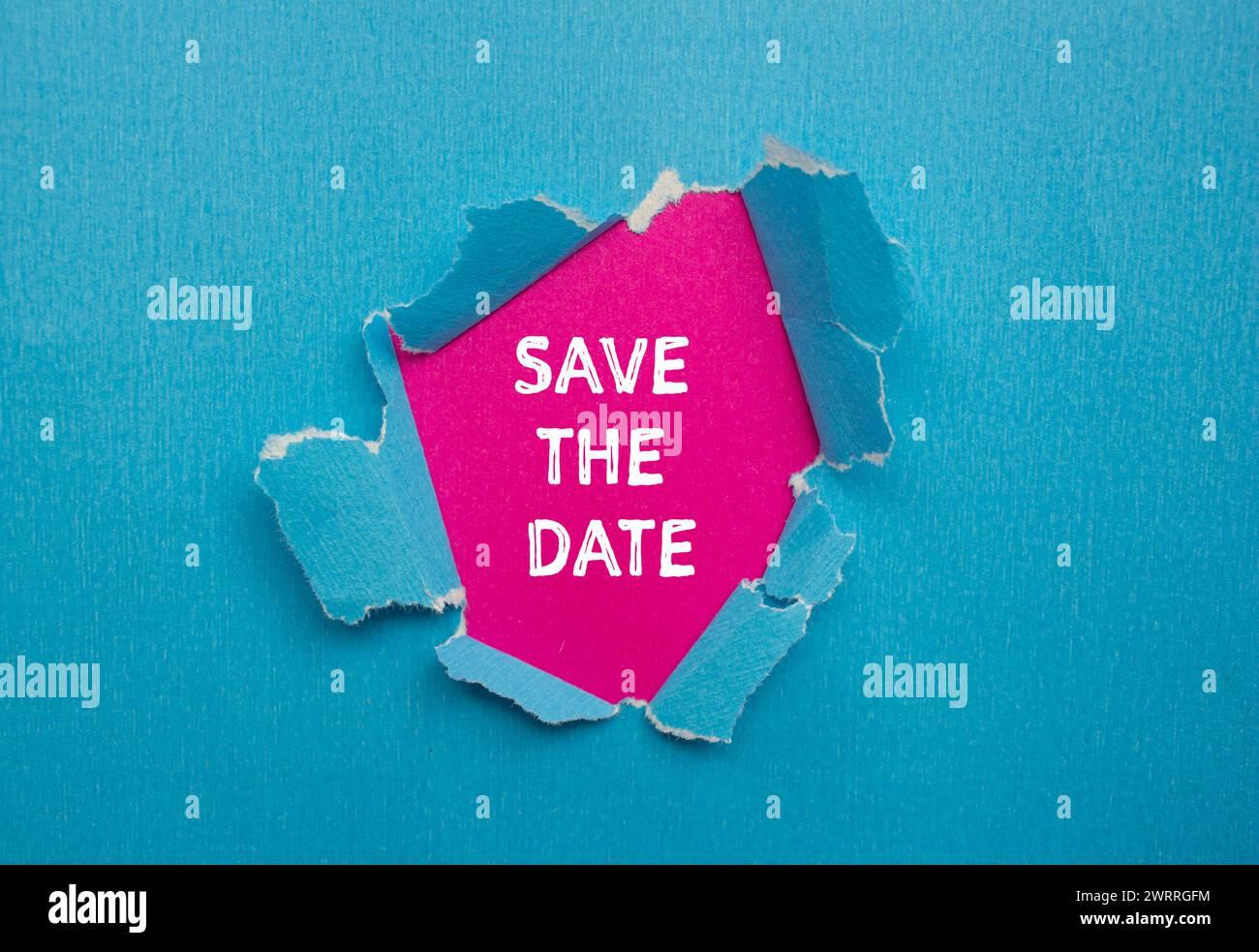 Save the date words written on blue torn paper with pink background ...
