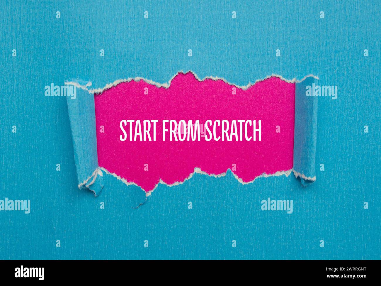 Start from scratch words written on blue torn paper with pink ...