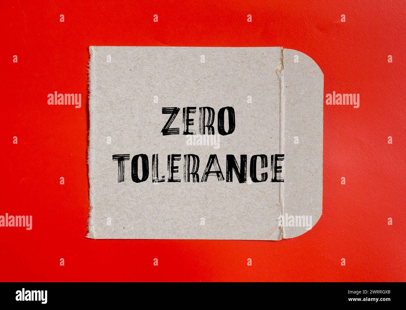 Zero tolerance words written on torn paper with red background. Conceptual photo. Copy space ...