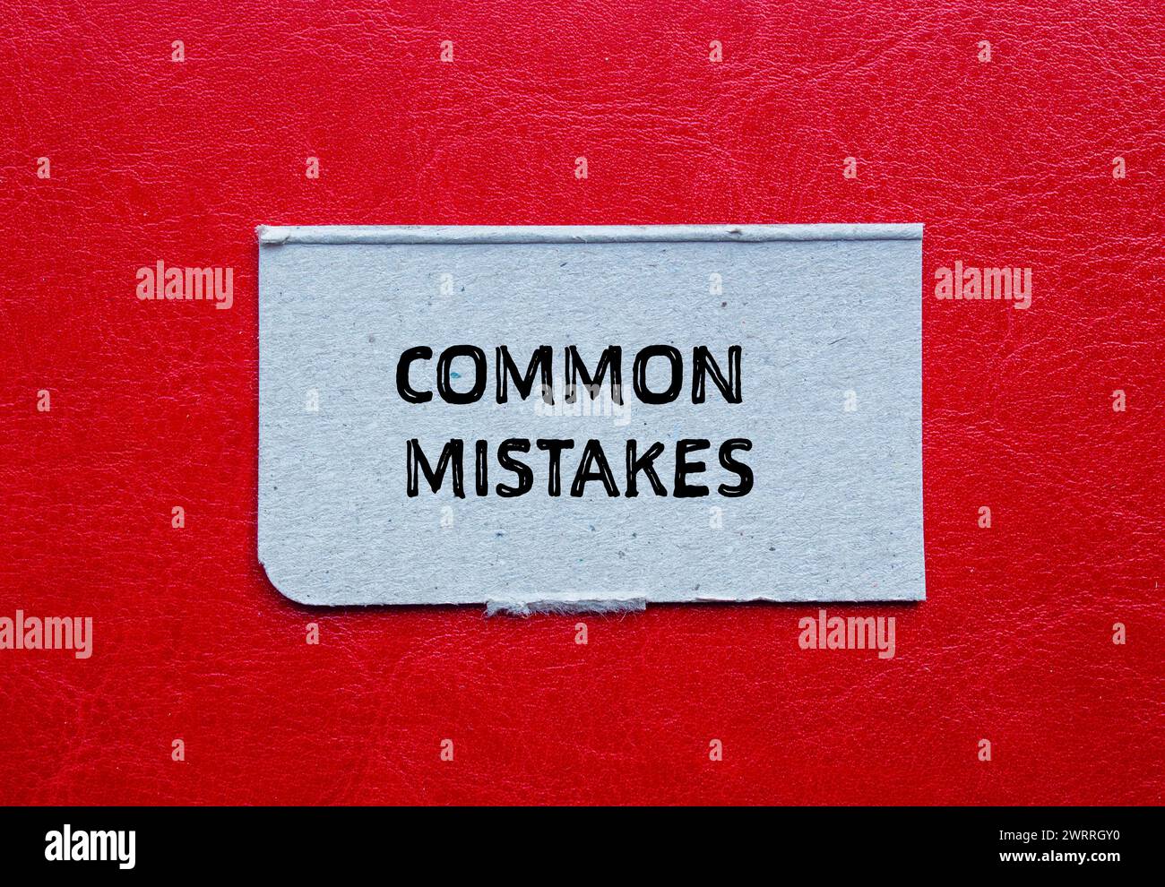 Common mistakes words written on torn paper piece with red background ...